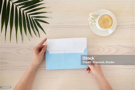 커피와 열대 잎 한 잔테이블에 파란색 봉투가 달린 인사말 카드를 여는 여성 손의 최고 전망 여성에 대한 스톡 사진 및 기타
