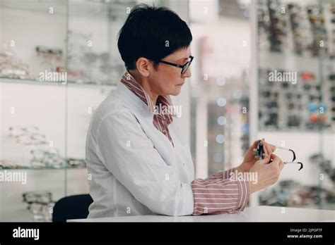 Happy Optician Choosing Eyeglasses Female Optometrist With Glasses