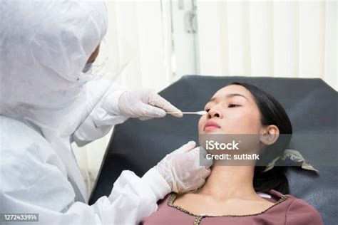 젊은 아시아 여성을위한 코로나 바이러스 검사를 만드는 면 봉면을 가진 보호 Ppe 정장의 의사 또는 의료 종사자 25 29세에