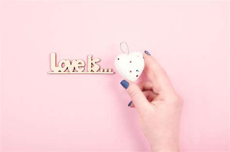발렌타인 파스텔 최소한의 창작 배경입니다 텍스트 사랑은 분홍색 바탕에 하얀 마음으로 여성의 손으로 발렌타인 데이 사랑 로맨스