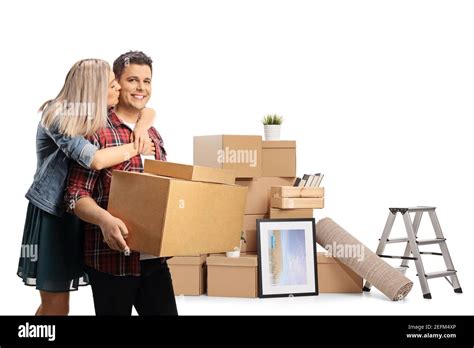 Woman Kissing A Man With Cardboard Boxes And A Pile Of Boxes Packed For Moving Into A New Home