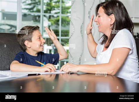 Mutter Hilft Sohn Bei Den Hausaufgaben Am Tisch Stockfotografie Alamy