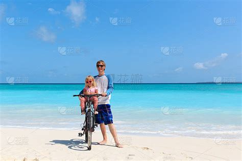 父亲和小女儿在海滩上骑自行车