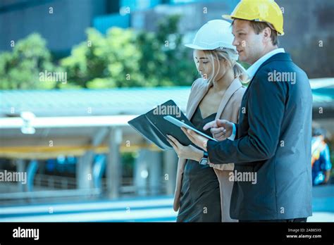 portrait of multiethnic architect with blueprints and business