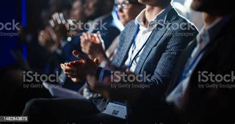 동기 부여 기조 연설을하는 동안 어두운 컨퍼런스 홀에서 박수를 치는 사람들의 군중의 손에 가까이 다가가십시오 비즈니스 기술 서밋