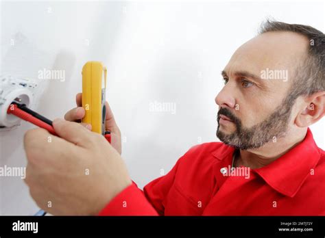 Mature Male Electrician Testing Socket With Multimeter Stock Photo Alamy