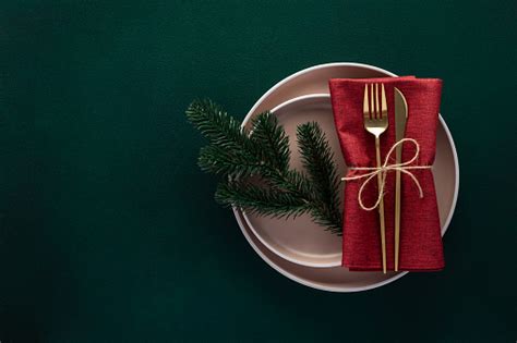 짙은 녹색 배경에 빈 접시와 황금 칼이 있는 크리스마스 또는 새해 저녁 식사 테이블 전나무가 있는 카드 또는 메뉴 템플릿 복사 공간 플랫 레이 디자인 평면도 겨울 방학