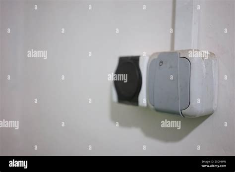 Two Electrical Outlets Are Mounted On The Wall One Is Showing Wear While The Other Is Clean