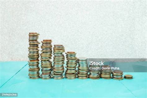 동전 스택 막대 차트 그래프 하향 추세 흰색 벽 배경 와 파란 나무 테이블 복사 공간 경기 침체 위기 인플레이션 스태그플레이션