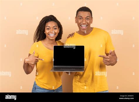 Cool Website Concept Happy Black Spouses Pointing At Laptop With Blank