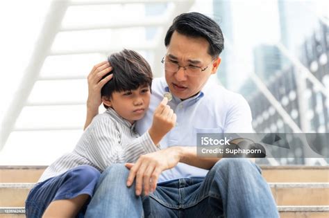 아버지와 아들은 공개 복도에서 슬픈 얼굴로 서로를 껴안고 아들의 손이 동전을 들고 있었는데 이는 그들이 가진 마지막 돈인 아빠와