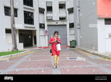 Ethnic Indian Woman Walks Out Of An Hdb Block In Sengkang Northeastern