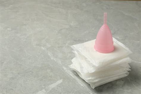 Menstrual Cup And Pads On Grey Table Space For Text Stock Image
