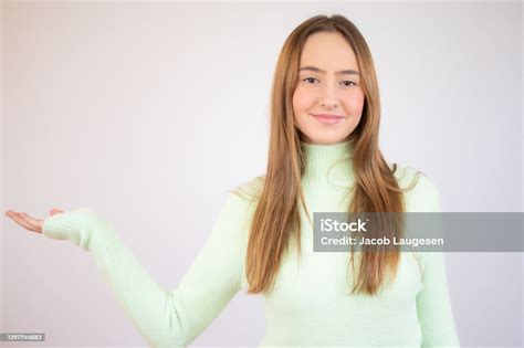 흰색 배경 위에 고립 된 그녀의 손바닥에 복사 공간을 들고 웃고있는 아시아 여성의 초상화 가리키기에 대한 스톡 사진 및 기타