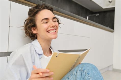 Retrato en primer plano de una mujer joven que escribe en su diario sintiéndose creativa sentada