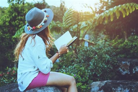 Premium Photo Side View Of Woman Sitting On Rock With Diary