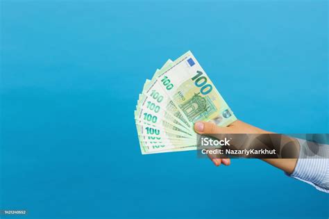파란 배경에 고립 된 백 유로 지폐를 들고있는 여성의 손 유로 돈 현금 지폐 여성에 대한 스톡 사진 및 기타 이미지 여성 접근성 통화 Istock