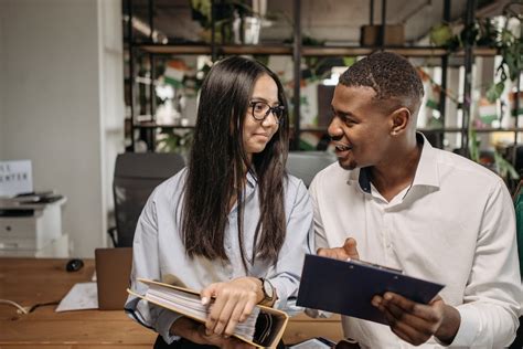 Woman In Gray Long Sleeve Shirt Sitting Beside Man In White Long Sleeve