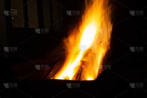 晚上炉火在烤架上燃烧。明亮的火 木。夜晚的火焰