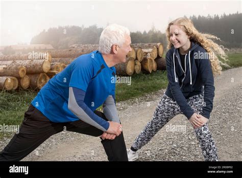Father With His Daughter Stretching Legs On Footpath And Smiling During