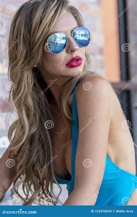 Hot Blonde Brazilian Model Posing Outdoors Against A Brick Wall Stock