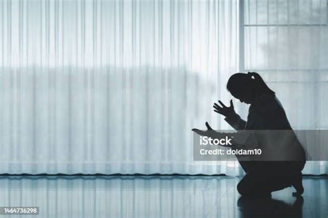 일몰 시간에 현대 교회에서 무릎을 꿇고 기도하는 여자의 실루엣 하느님께 드리는 여성 가톨릭 기도 예배는 믿음으로 새벽에 가정에서