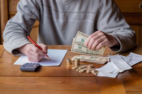 Premium Photo Midsection Of Man Calculating Money At Table