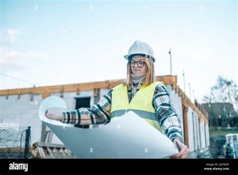 Portrait Of 30s Architect Engineer Womanin Clothes And Helmets With Documents At A Construction