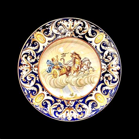 Piatto In Maiolica Con Tesa Decorata A Girali Fogliate E Scena