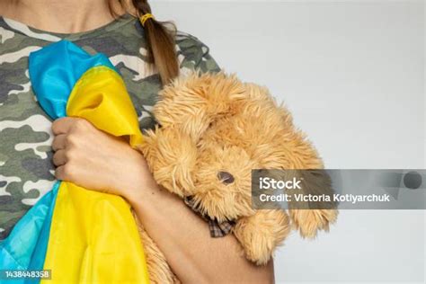 봉제 토끼와 흰색 배경에 손에 우크라이나 국기를 든 군복을 입은 여성 집으로 돌아가다 군인 여성 전쟁 2022 아이에 대한 스톡