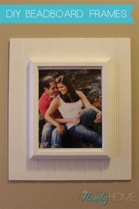 A White Frame Hanging On The Wall With A Blue Ribbon Around It That