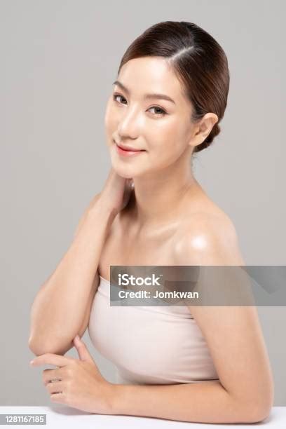 美しいアジアの女性は白い背景に隔離美容化粧品とスパトリートメントコンセプト肯定的な感情的な陽気な清潔で新鮮な肌の幸福と陽気でタッチネックを