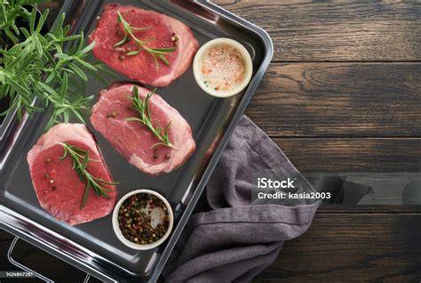 스테이크 오래된 나무 배경에 부엌 트레이에 향신료 로즈마리와 후추를 곁들인 신선한 Filet Mignon 스테이크 상단 보기 0