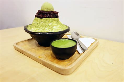 그릇에 달콤한 팥 또는 한국 면도 아이스 디저트와 빙수 녹차 나무 테이블 배경에 달콤한 토핑과 말차 아이스크림 음식 식사 디자인