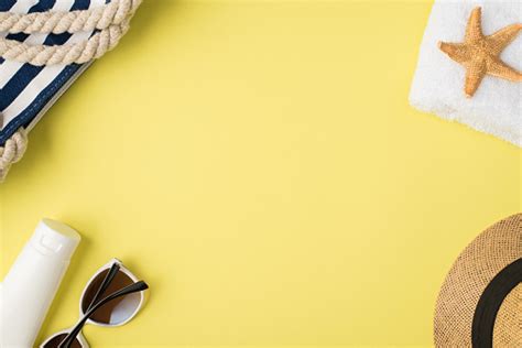 카피 스페이스와 고립 된 파스텔 노란색 배경에 비치 백 수건 불가사리 선햇 크림 병 선글라스의 최고 보기 사진 0명에 대한 스톡