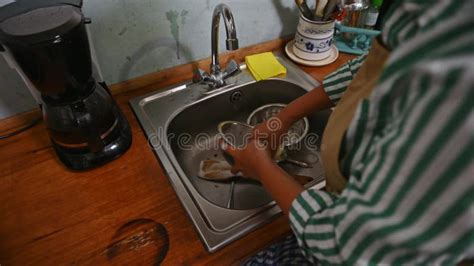 Washing Dishes In A Modern Kitchen Featuring A Vibrant Red Background