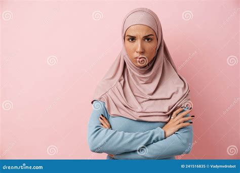 A Sad Muslim Woman Wearing Pink Hijab Standing With Crossed Arms Stock