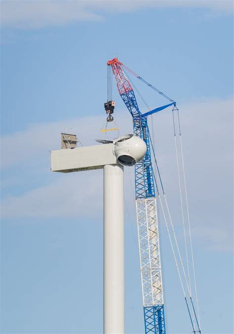 Crane Lifts The Nacelle Onto A Wind Turbine Tower During The