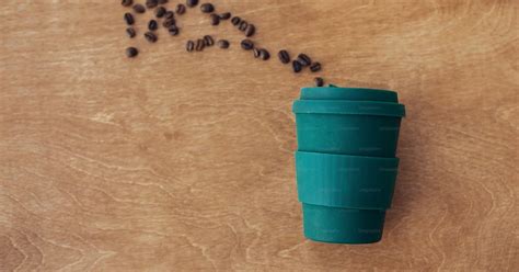 제로 폐기물 개념 플랫 레이 볶은 커피 원두가 있는 나무 배경에 세련된 재사용 가능한 에코 커피 컵 일회용 플라스틱을 금지합니다 지속 가능한 라이프 스타일 천연