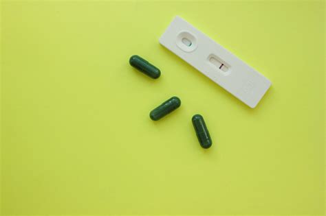 노란 배경에 부정적인 임신 테스트 와 알 약 모성 어린이 임신 피임 개념 건강 문제 및 임신 문제 낙태 피임 공간을 복사합니다