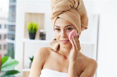 Premium Photo Young Happy Woman In Towel Making Facial Massage With