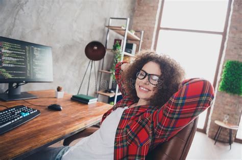 Smiling Young Female Programmer Relaxing At Desk In Modern Home Office With Coding On Computer