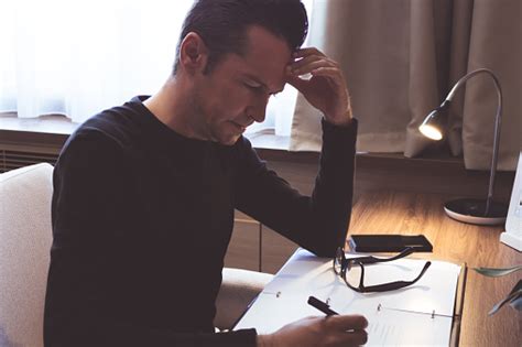 프리랜서 노동자는 자신의 홈 오피스에서 책상에서 쓰기 쓰기에 대한 스톡 사진 및 기타 이미지 쓰기 얼굴을 손에 기댐 걱정하는 Istock