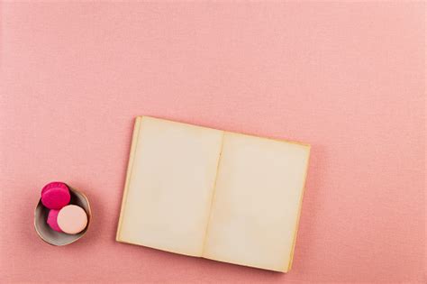 예술 또는 텍스트 배치에 대 한 좋은 Copyspace 핑크 식탁보 배경 위에 분홍색 프랑스 마카롱 또는 마카롱 측면에 빈 고
