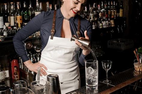 Smiling Female Bartender Pouring An Alcohol Into The Glass With Stock