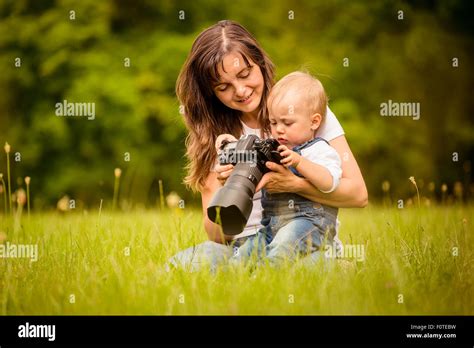 Mother Showing Her Kid Captured Photos On Dslr Camera Outdoor In Nature Stock Photo Alamy
