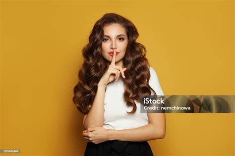 아름다운 젊은 모델 여성은 입술에 발가락 손가락을 유지 침묵 제스처를 보여줍니다 노란색 배경에 비밀리에 기밀 정보를 유지하도록