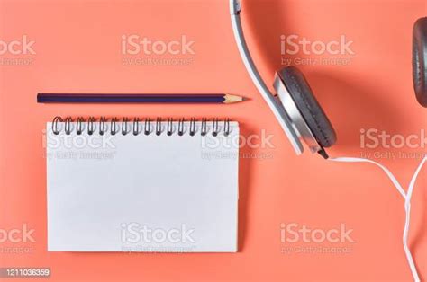 빈 종이 노트북 과 오렌지 배경에 연필 근처 케이블 현대 흰색 헤드폰 음악 개념입니다 공간을 복사합니다 맨 위 보기 Dj에 대한