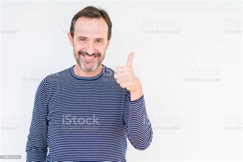 행복 한 엄지손가락 손으로 제스처를 하 고 격리 된 배경 위에 잘생긴 수석 남자 승인 성공을 보여주는 카메라를 보고 하는 식