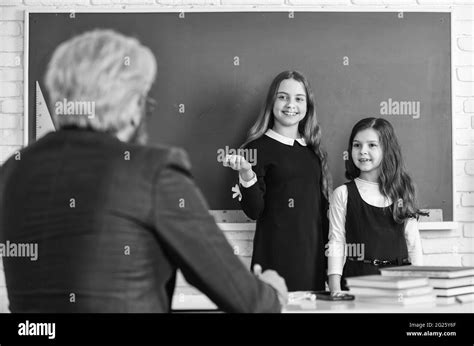 Back To School Help And Support Elementary Pupil With Teacher In